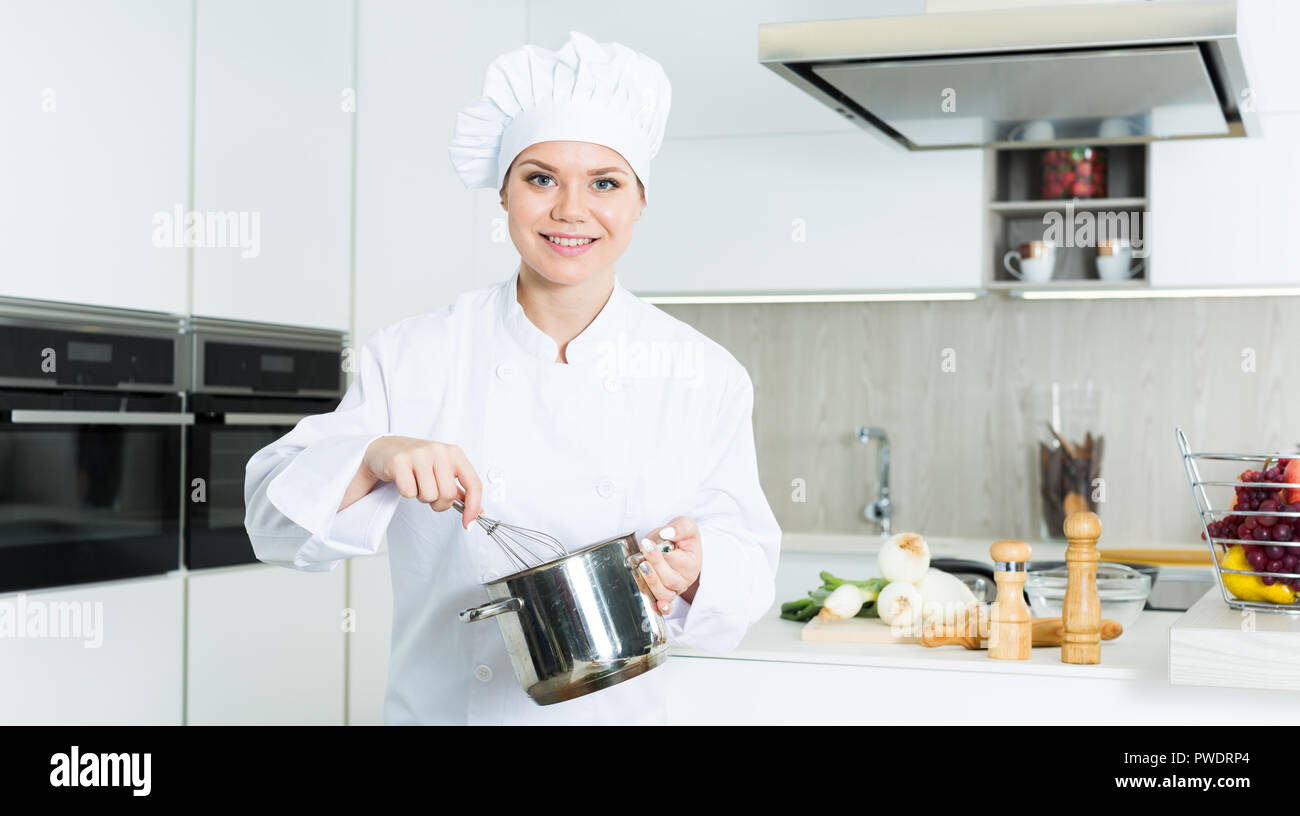 Woman professional is cooking soup in the kitchen at the cafe Stock ...