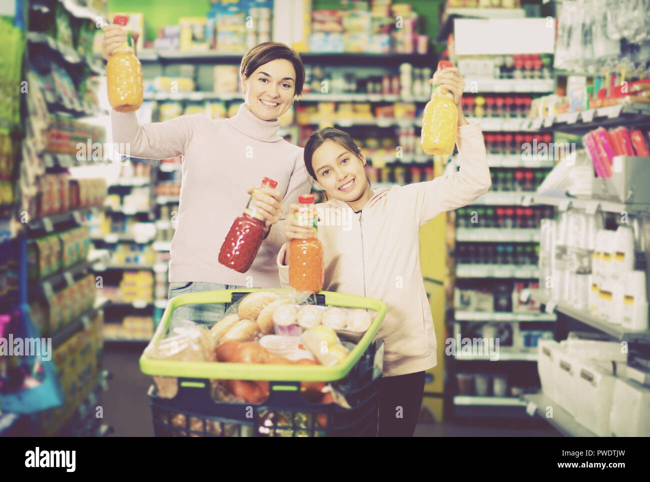 Glad woman customer with girl looking for refreshing beverages in ...
