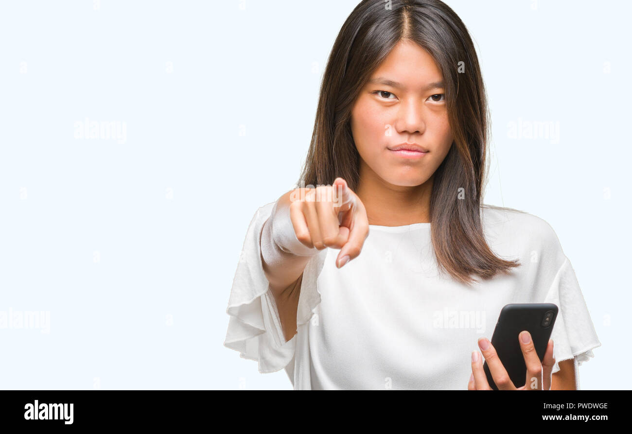 Young asian woman texting using smartphone over isolated background ...