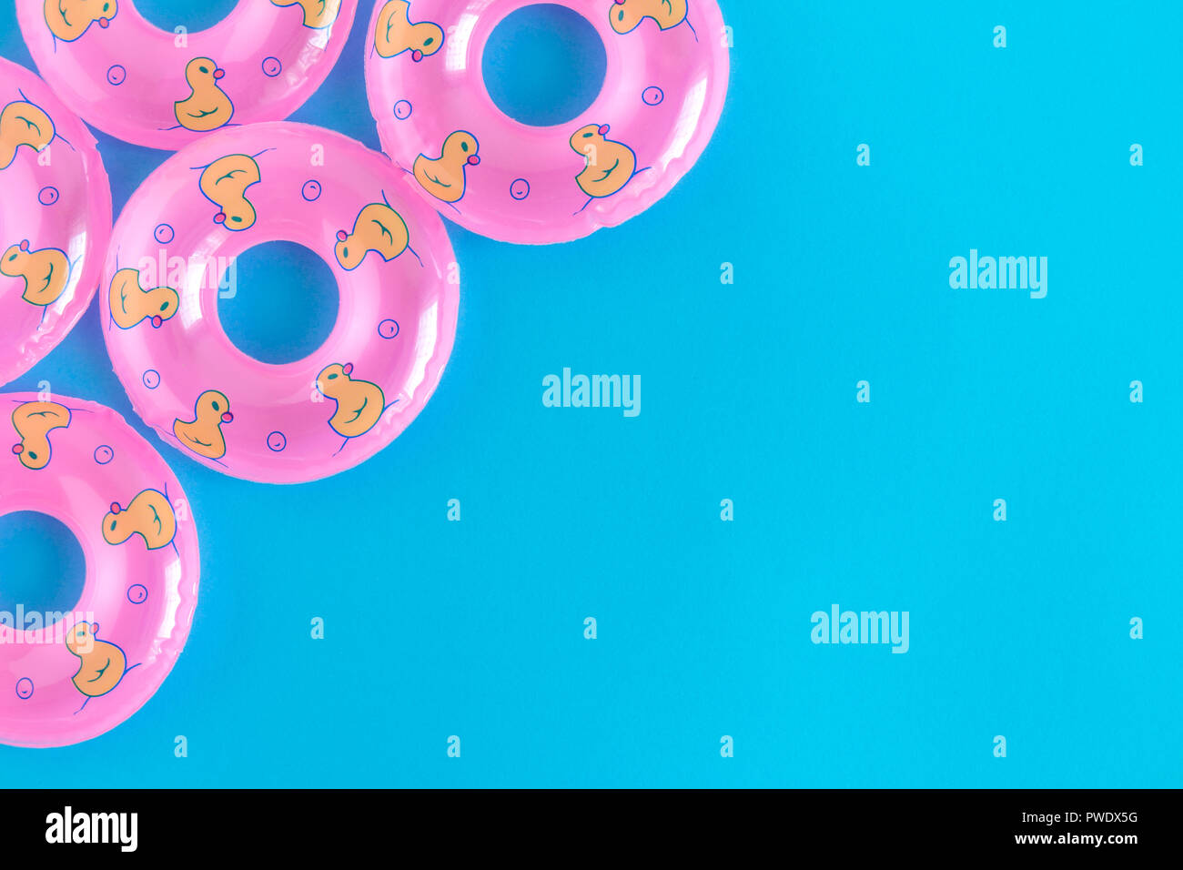 Flat lay of inflatable, pool floats against pastel blue background ...