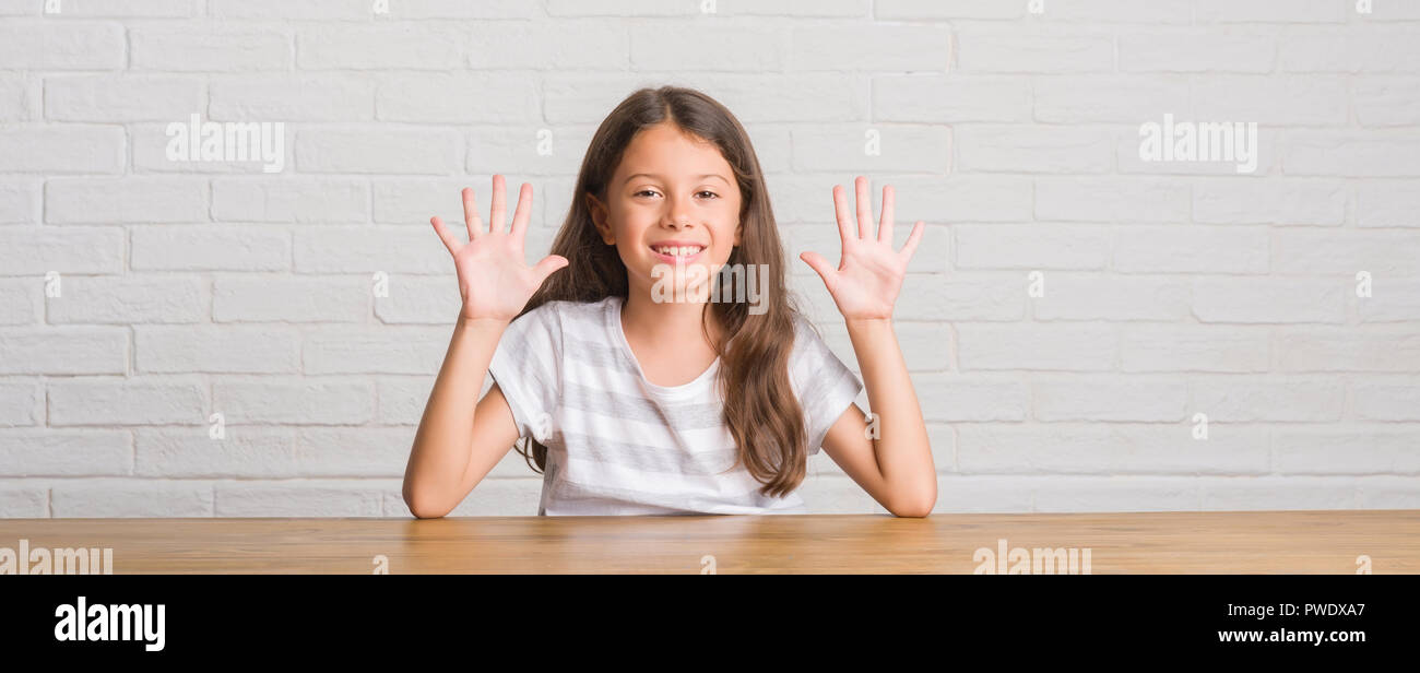 Young hispanic kid sitting on the table at home showing and pointing up ...