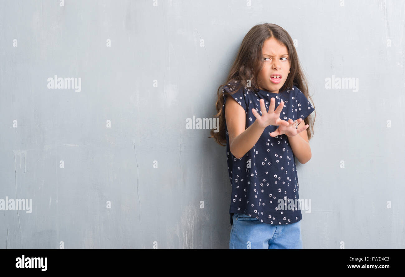 Young hispanic kid over grunge grey wall disgusted expression ...