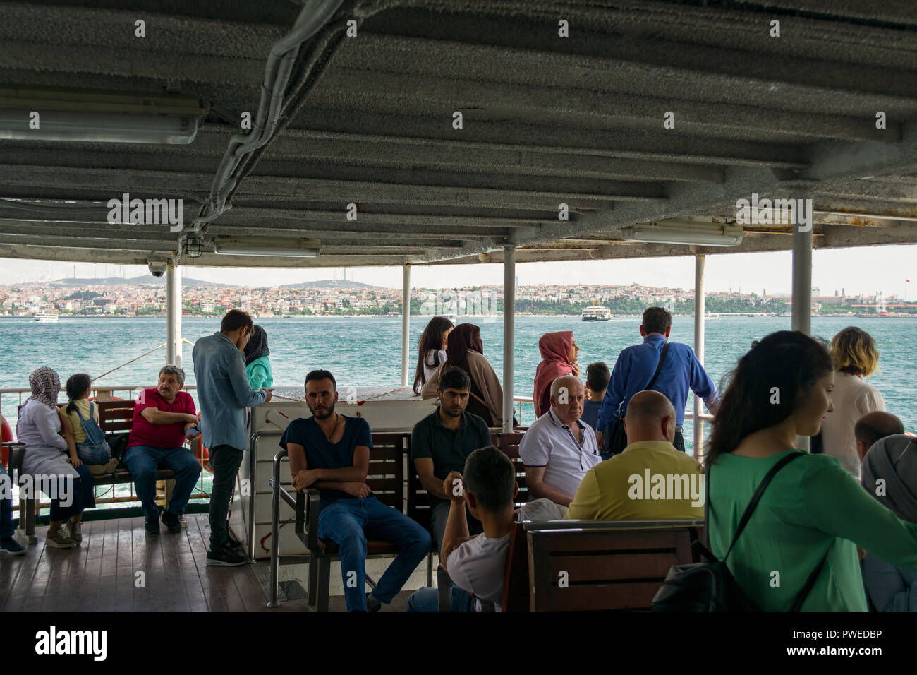 Passengers sat in the shaded seating area of a ferry as it travels on ...