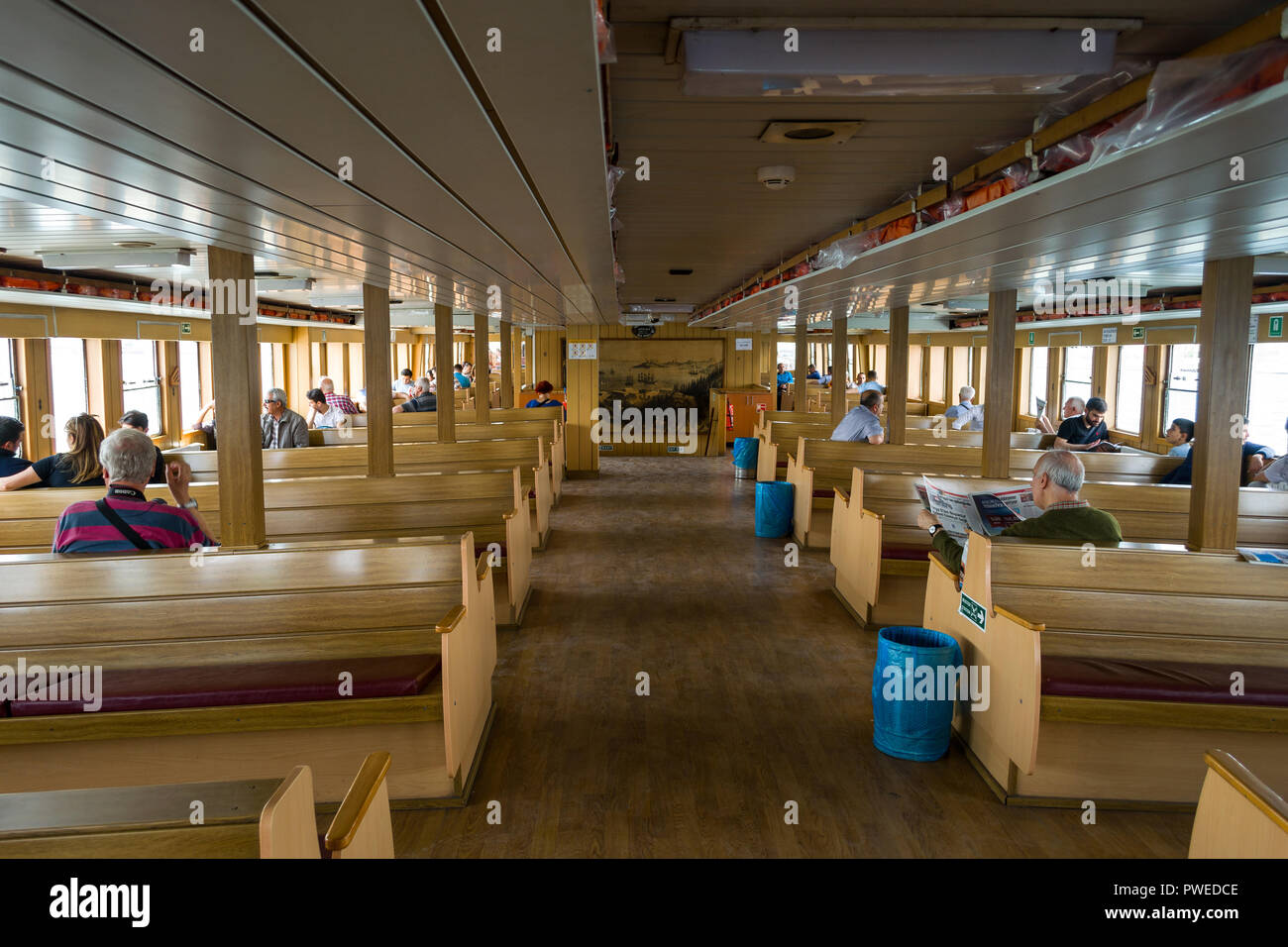 Passengers sat in the shaded seating area of a ferry as it travels on ...