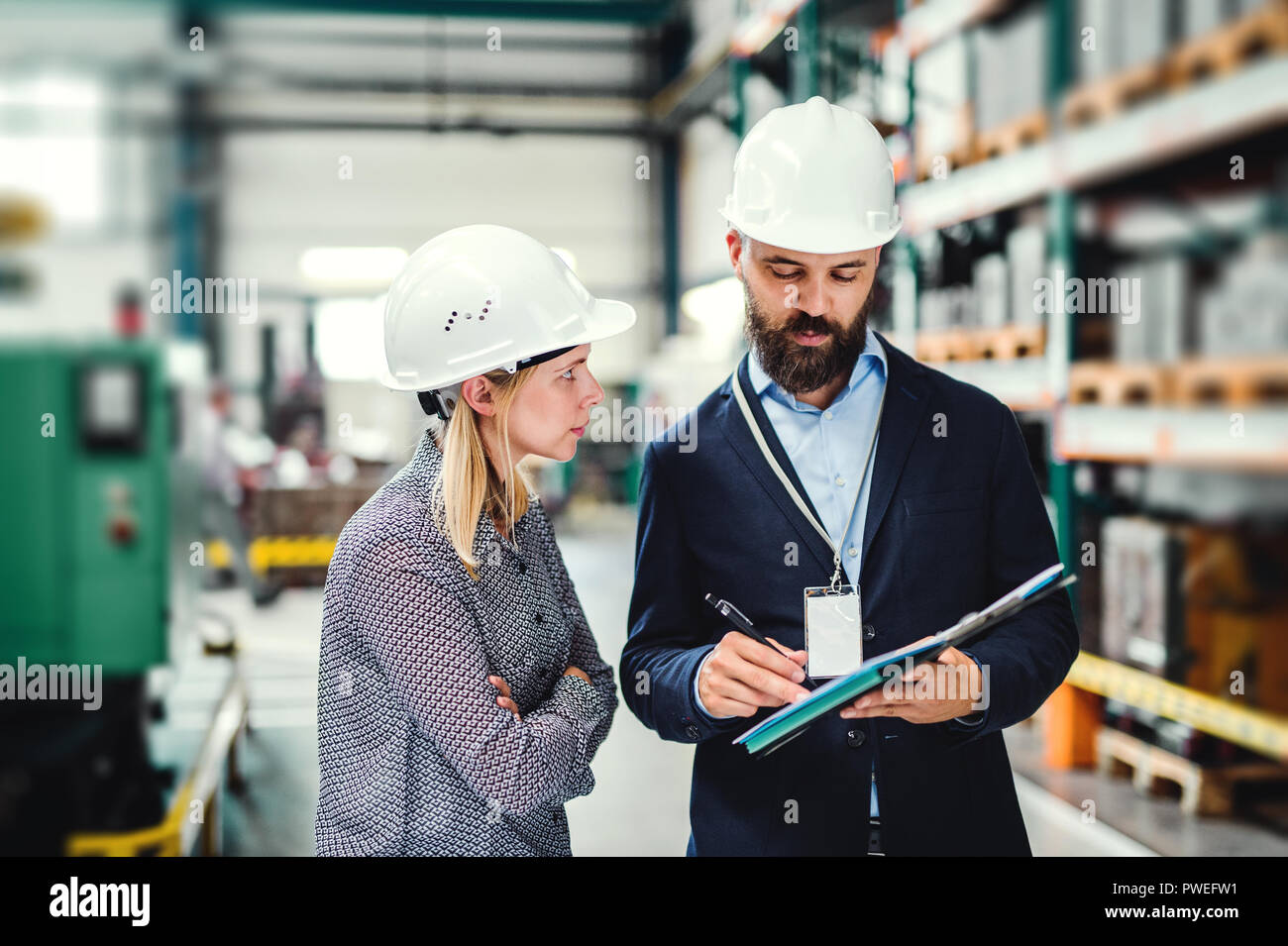 A portrait of a serious mature industrial man and woman engineer with ...