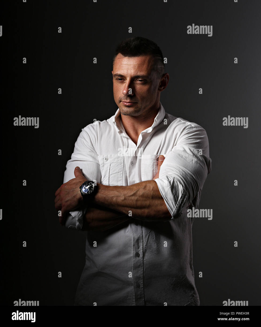 Brutal serious business man thinking with sporty biceps folded arms in ...