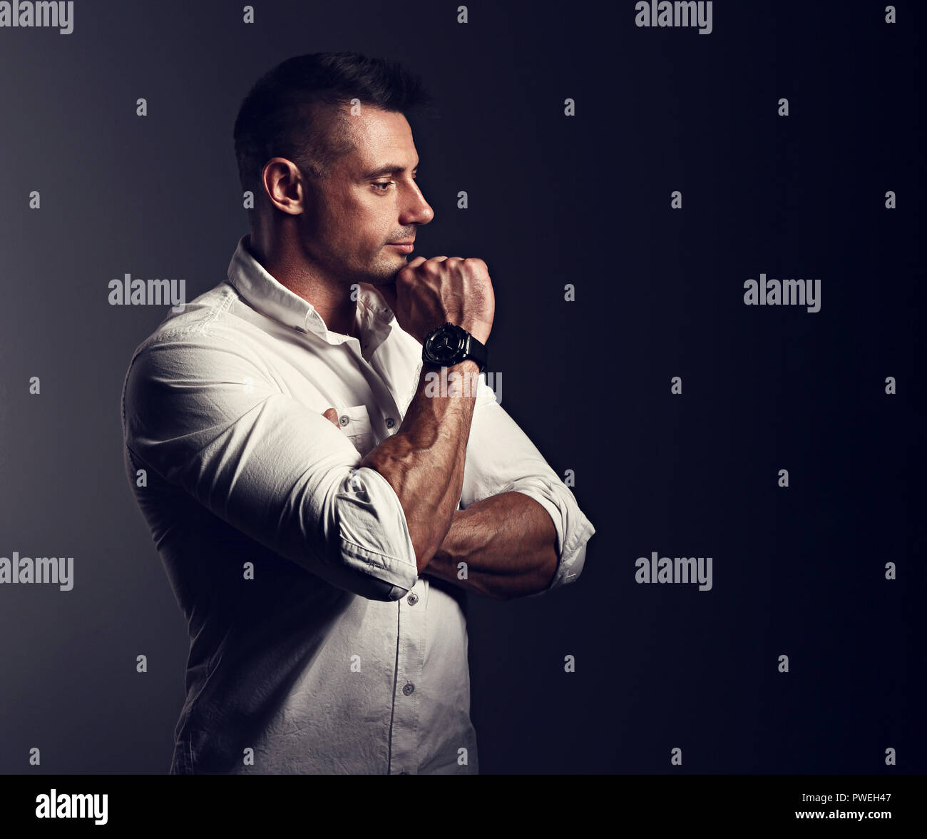 Strong serious business man thinking with sporty biceps arms in white ...