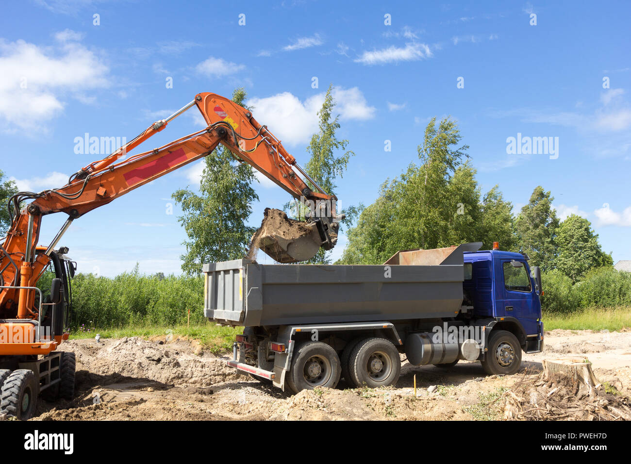 The excavator loads the tipper truck on construction site Stock Photo ...