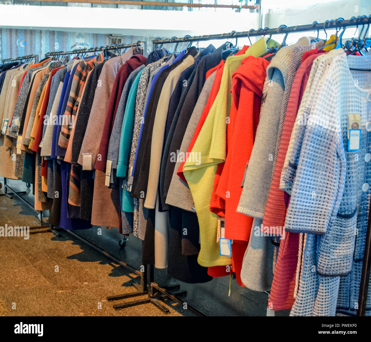 Coats and jackets on hangers in the store. Sale of outerwear Stock ...