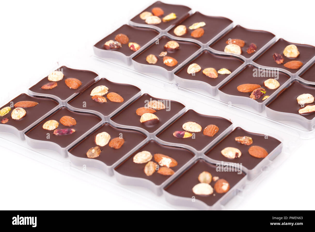 Chocolate with assortment nuts in plastic boxes isolated on white ...
