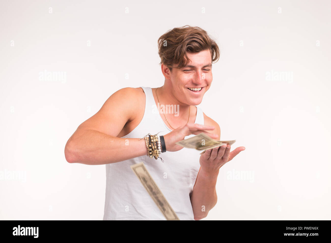 Rich, fun and finance concept - handsome young man throws money over ...