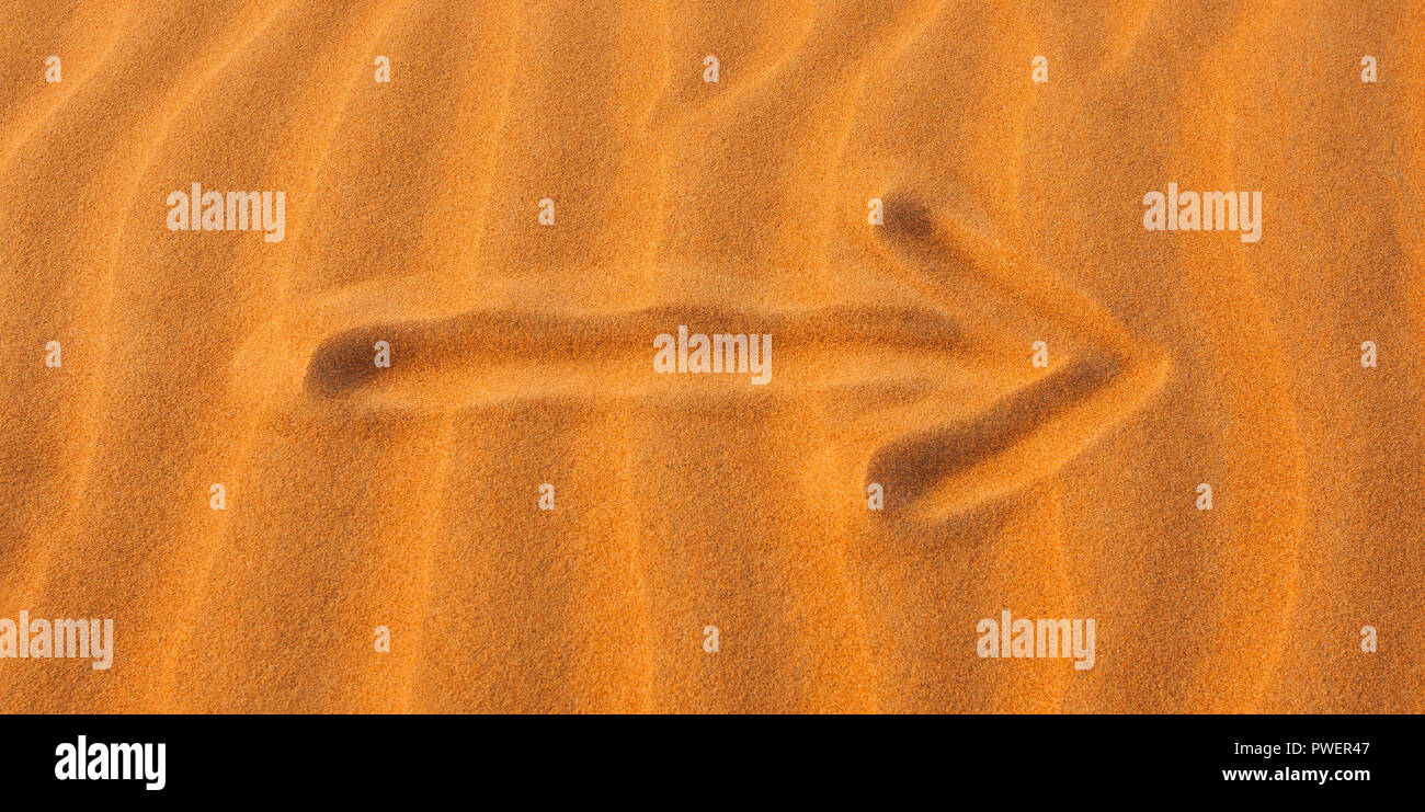 arrow in the desert sand pointing right Stock Photo - Alamy