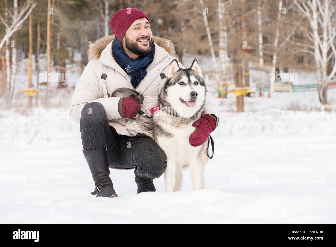 Full length portrait of modern Asian man posing with gorgeous Husky dog ...