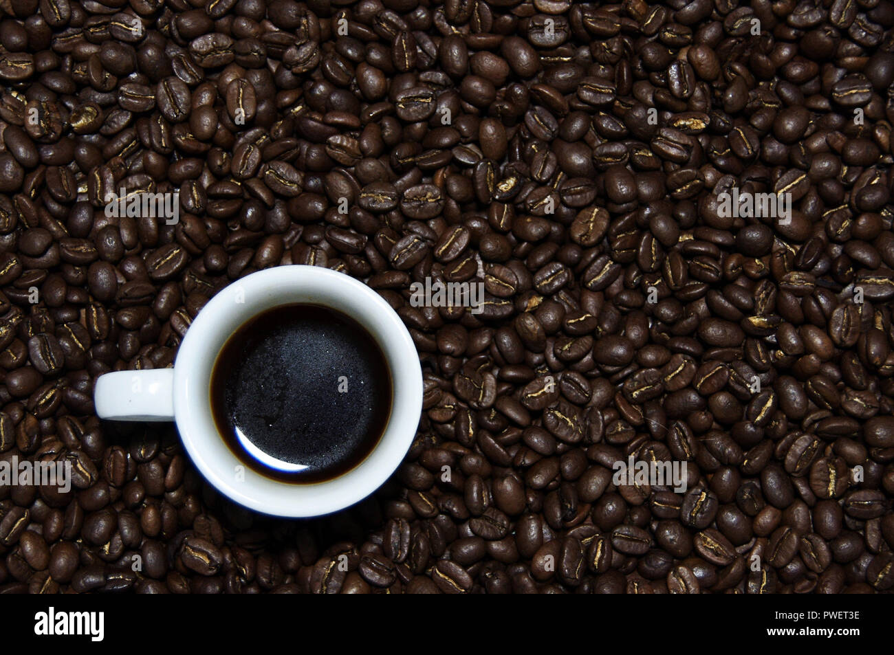 cup with coffee in a cup in the middle of coffee beans Stock Photo - Alamy