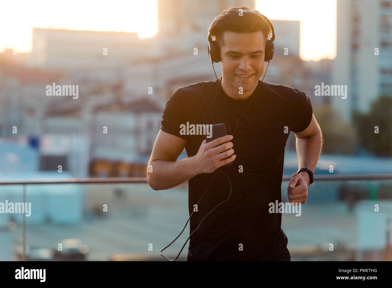 Handsome man running and listening Stock Photo - Alamy