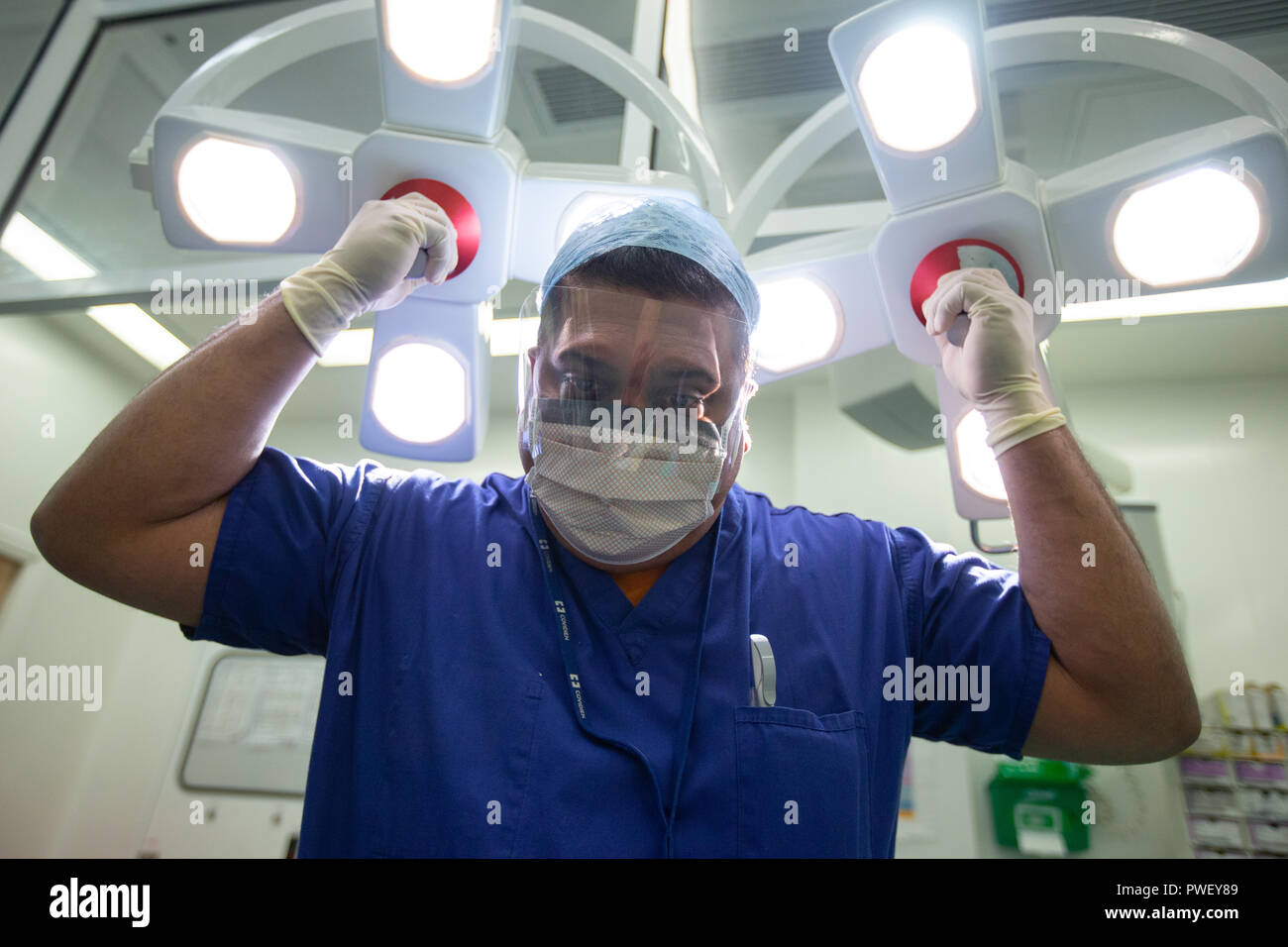 Patient's eye view of a surgeon adjusting the lights in an operating ...