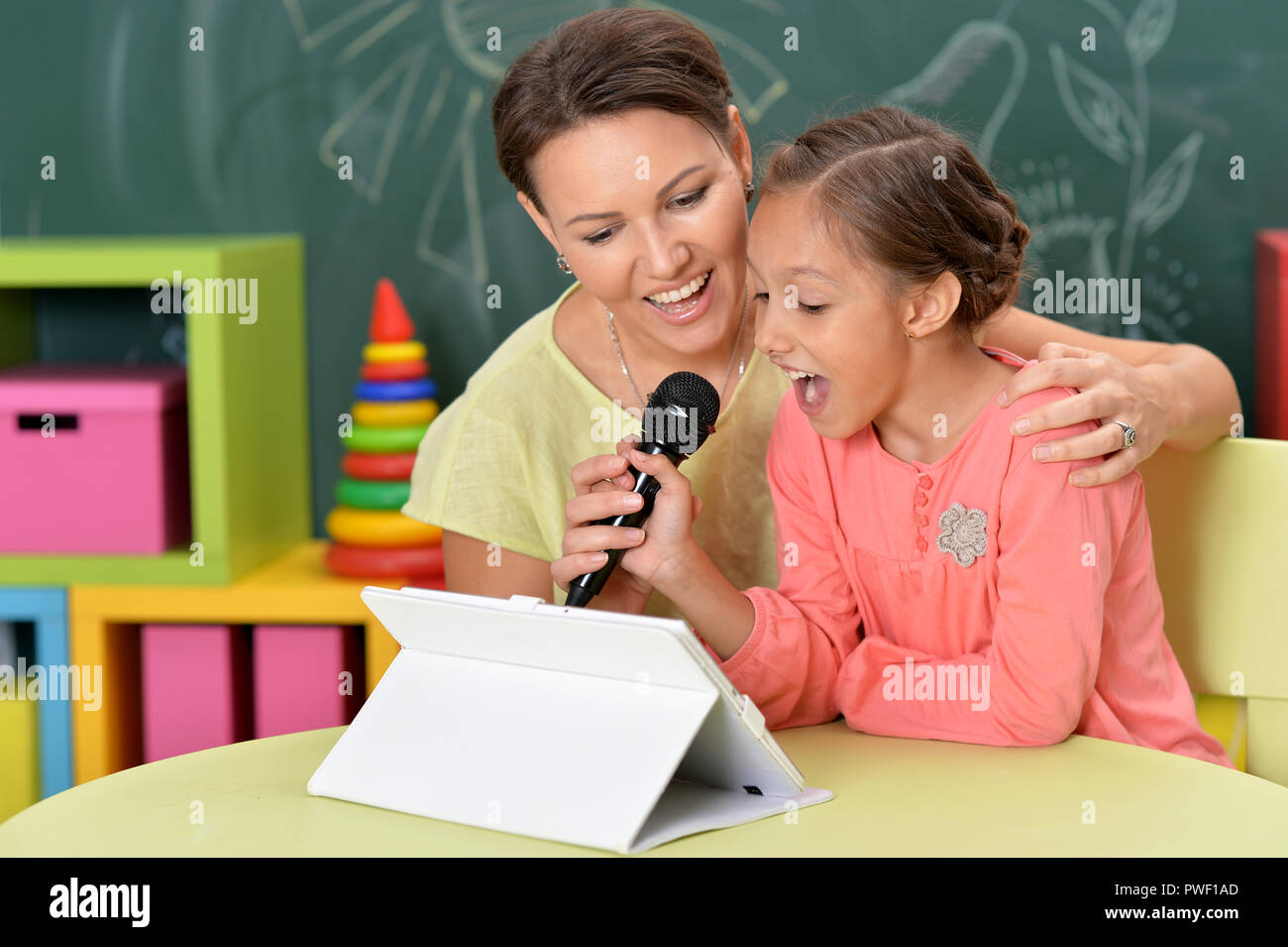 mother and daughter singing karaoke with microphone together Stock ...