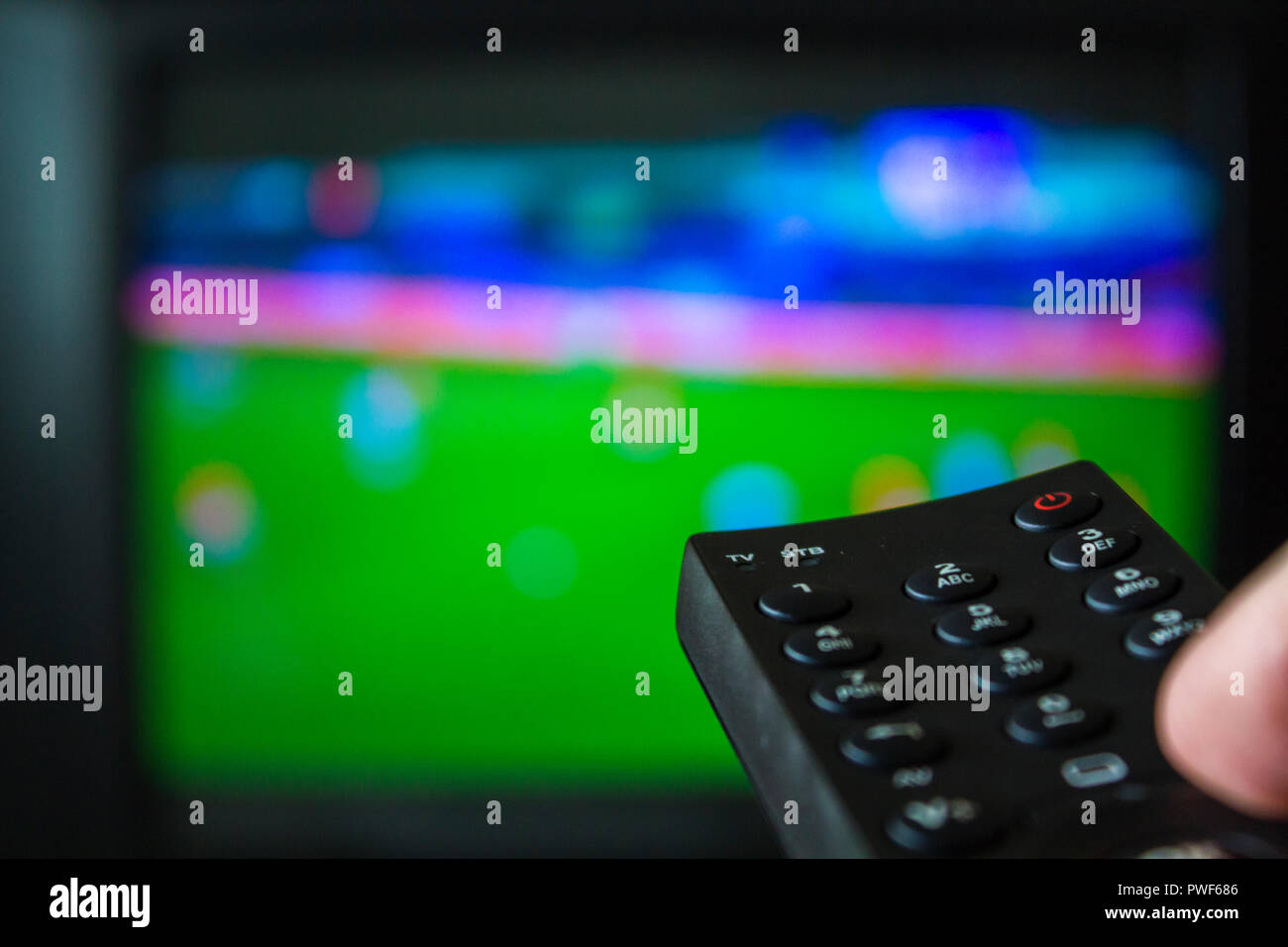 Watching football game hand holding television remote control Stock ...