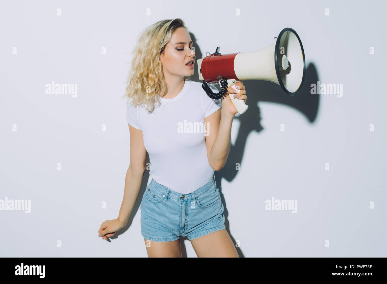 Young girl shouting by megaphone isolated on white background Stock ...