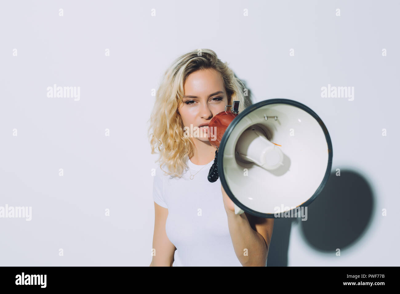 Young girl shouting by megaphone isolated on white background Stock ...