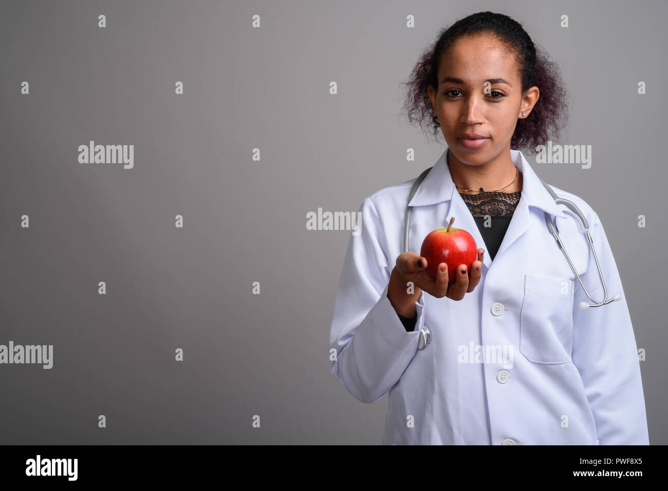 Young beautiful African woman doctor against gray background Stock ...