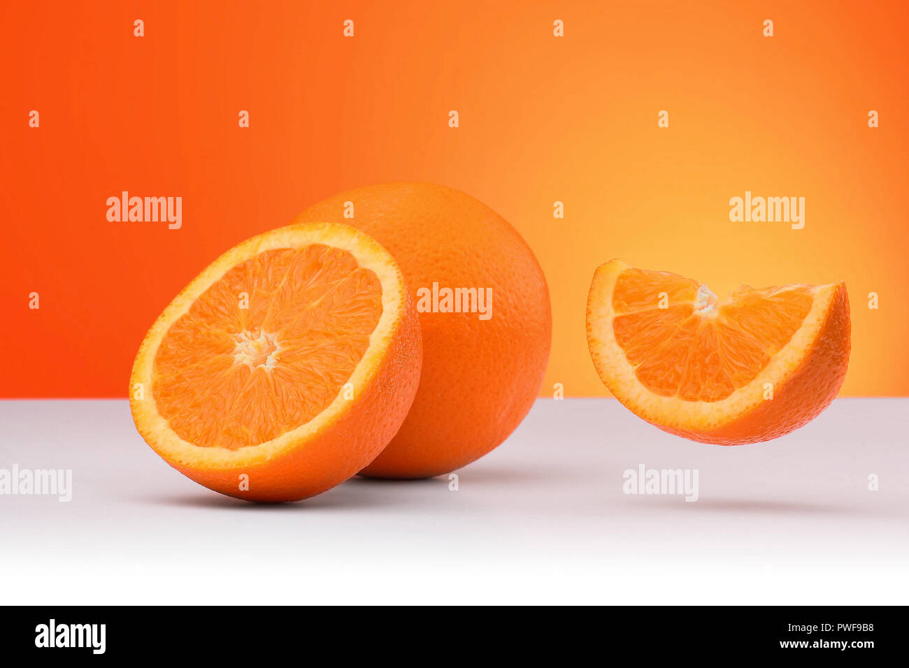 Group of oranges isolated on an orange and white background with space ...
