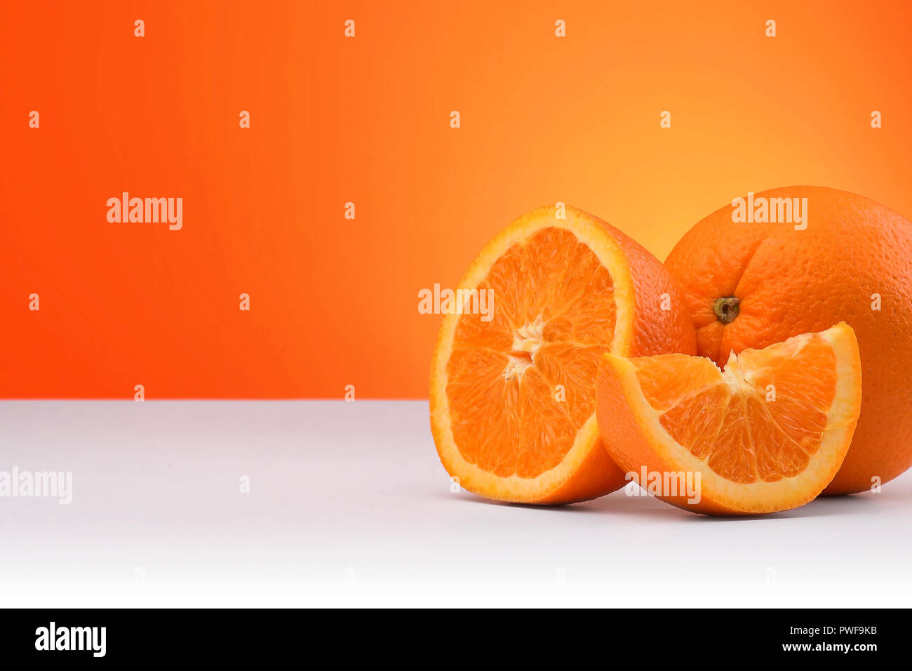 Group of oranges isolated on an orange and white background with space ...