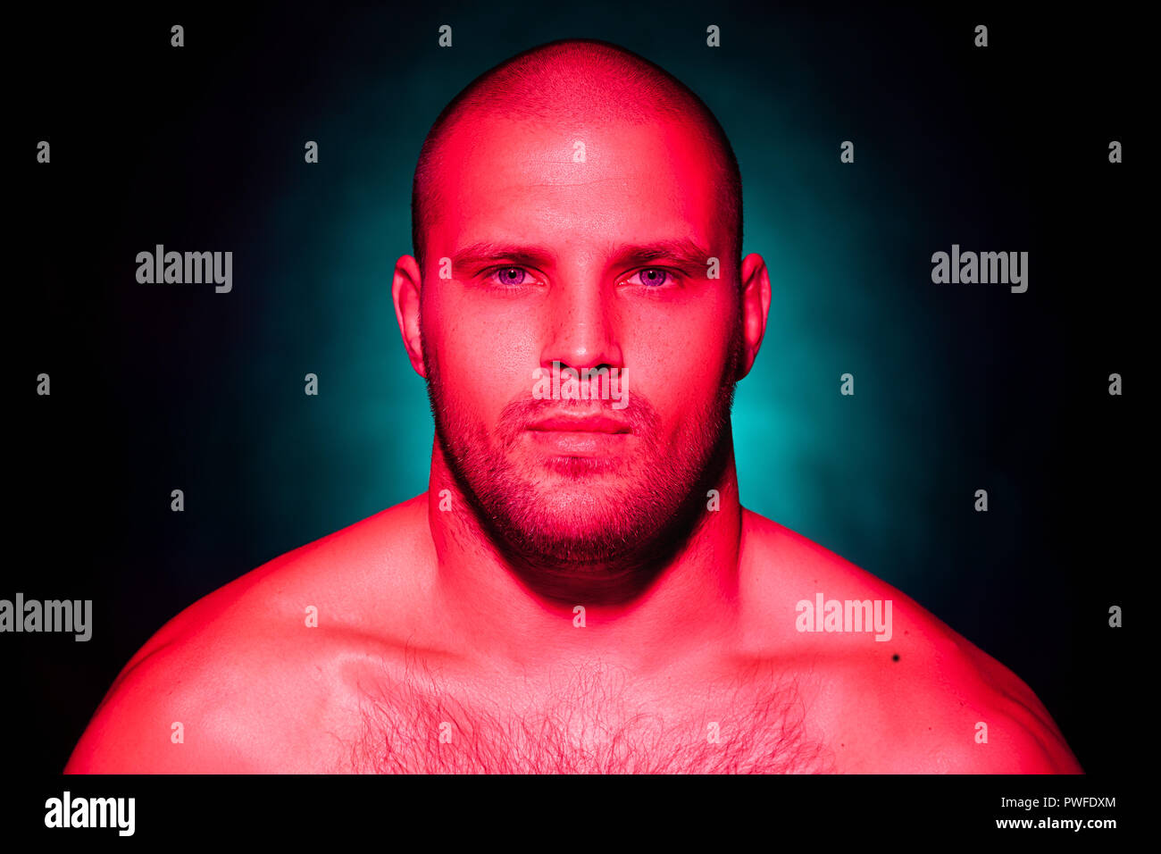 Serious young bald man standing isolated on a black background and ...