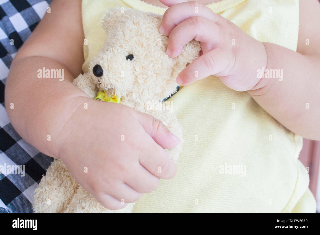 hand of baby boy holding teddy bear for play Stock Photo - Alamy