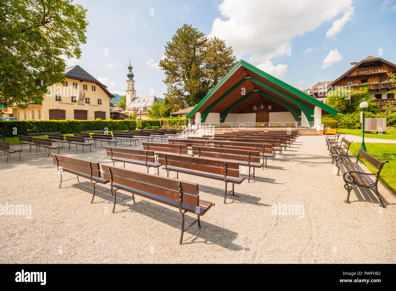 Outdoor stage with rows of wooden benches in austrian alpine village St ...