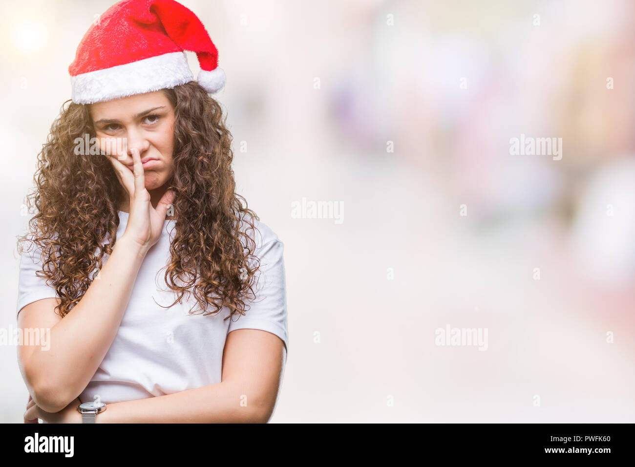 Young brunette girl wearing christmas hat over isolated background ...