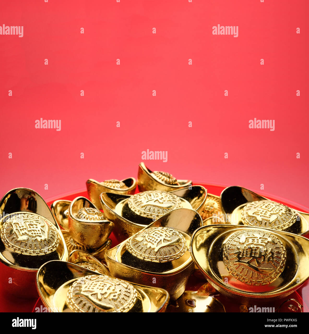 group of golden ingots on red tray at red background.Chinese new year ...
