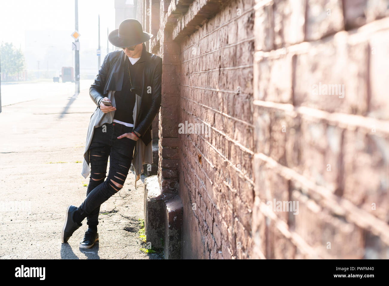 Young man posing with a trendy outfit against a urban background Stock ...