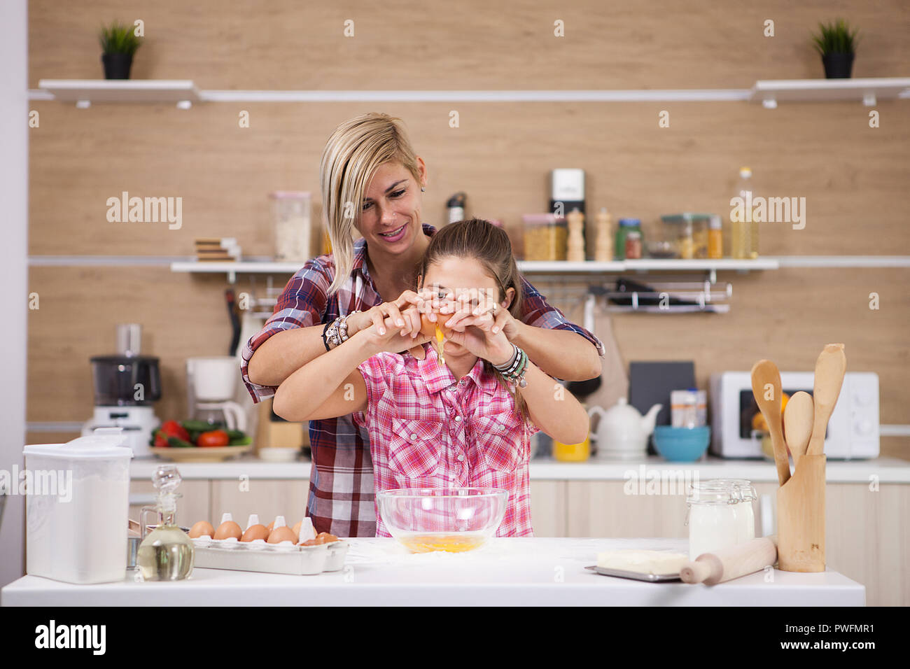 Portrait of happy mother and daughter smiling while cooking. Healthy ...