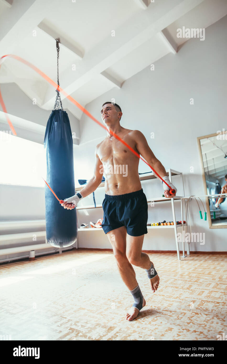 Young man skipping rope in gym. Cardio and fitness workout. Sport ...