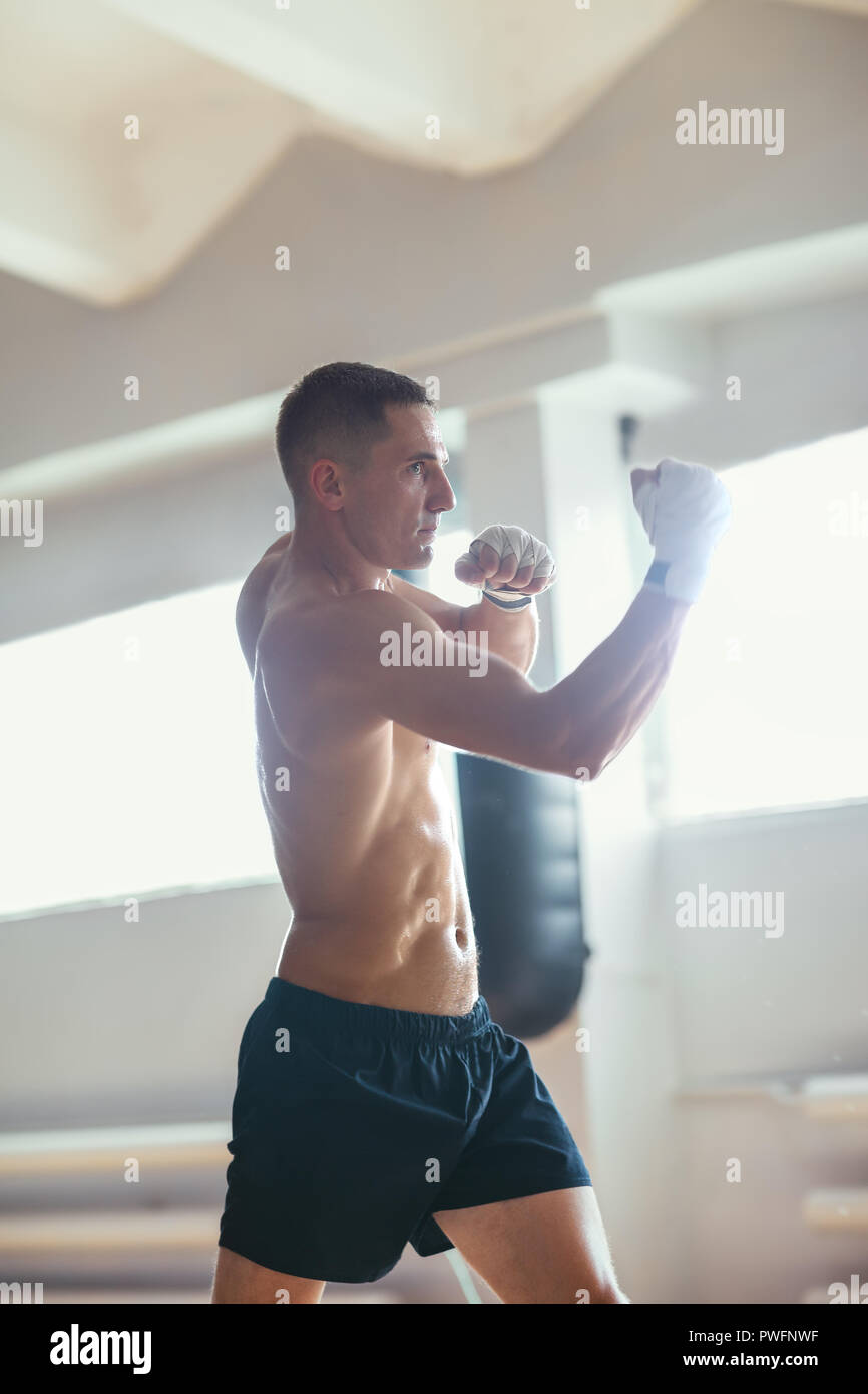 Sportsman muay thai boxer fighting on gym. Muscular man works out best ...