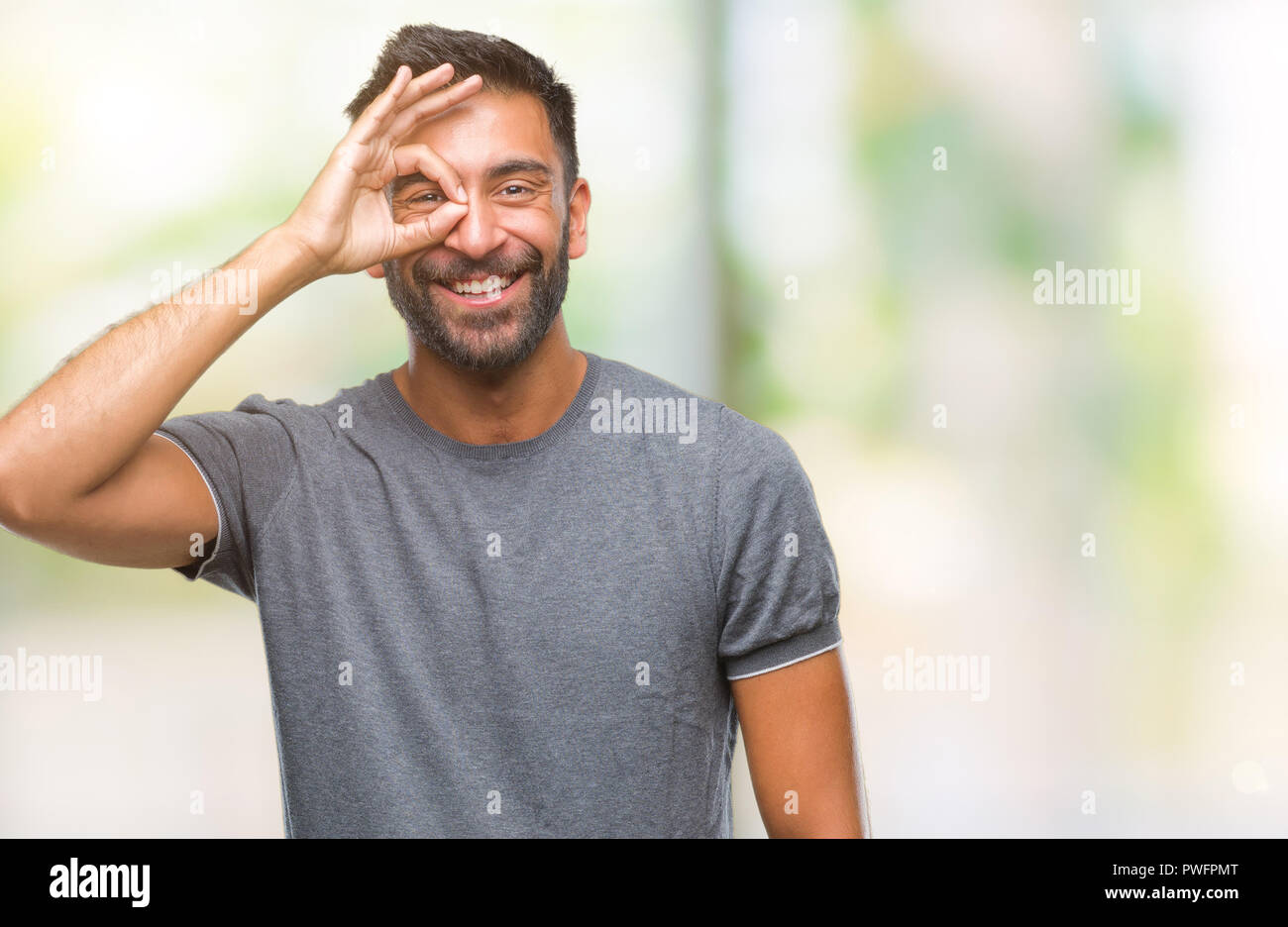 Adult hispanic man over isolated background doing ok gesture with hand ...