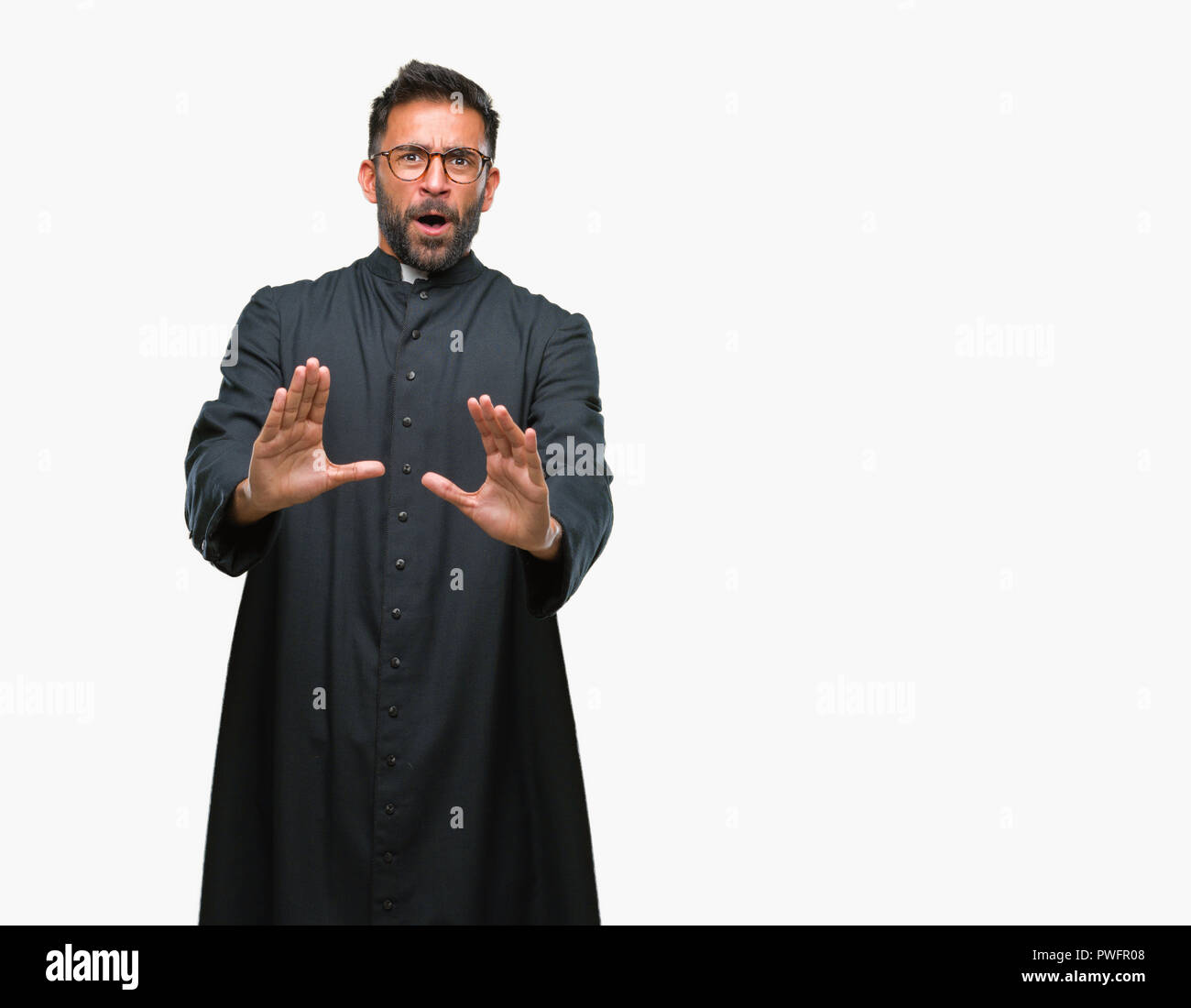 Adult hispanic catholic priest man over isolated background afraid and ...