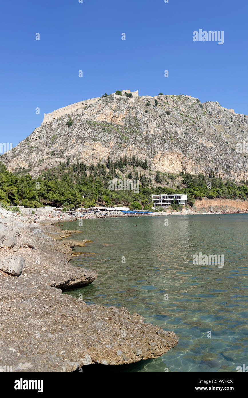 View of the small pebble Arvanitia Beach and the imposing Fortress of ...