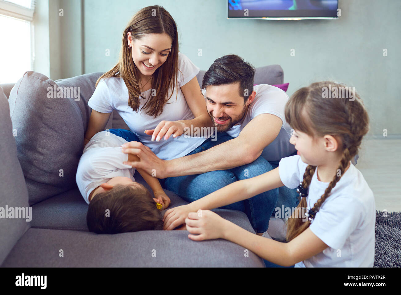 Cheerful family playing together in a room in the daytime Stock Photo ...