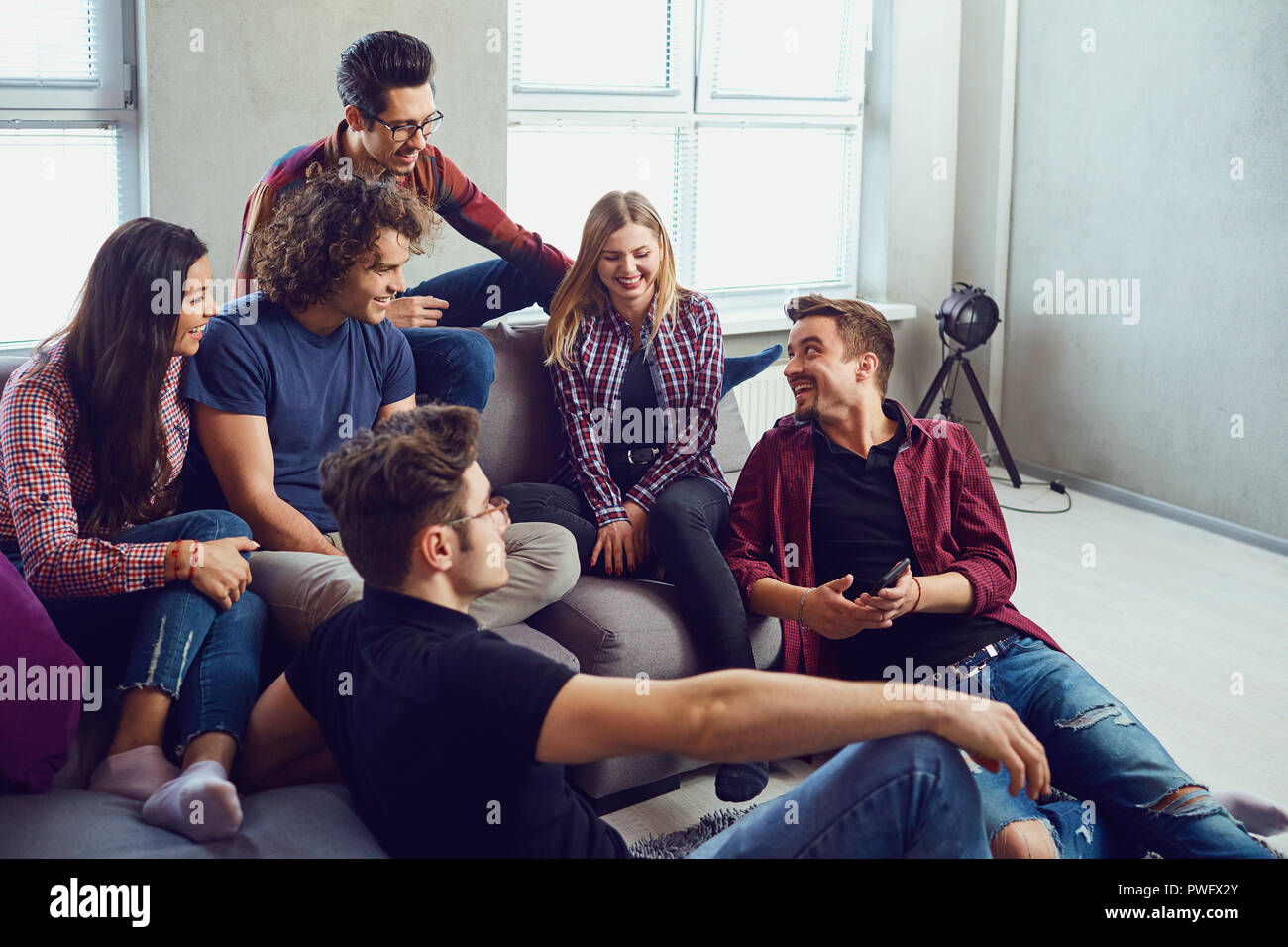A group of friends at a meeting talking together sitting on a sofa in ...