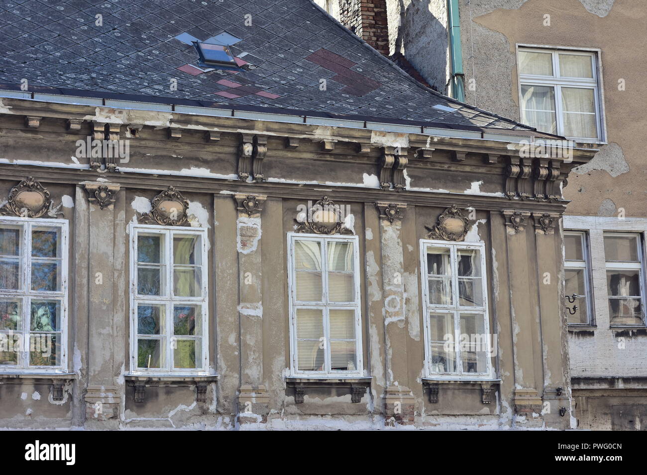 Weathered old apartment houses with tall multi pane windows and pain ...