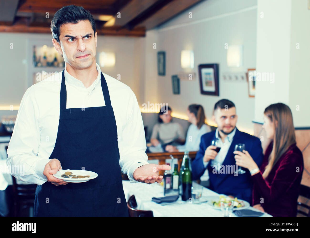 Portrait of waiter dissatisfied with small tip from cafe visitors Stock ...