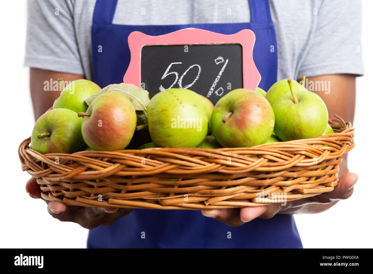 Basket of fresh apples at fifty percent off with discount sign held by ...