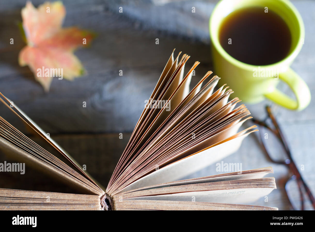Open book autumn leaves tea and glasses abstract background on wooden ...