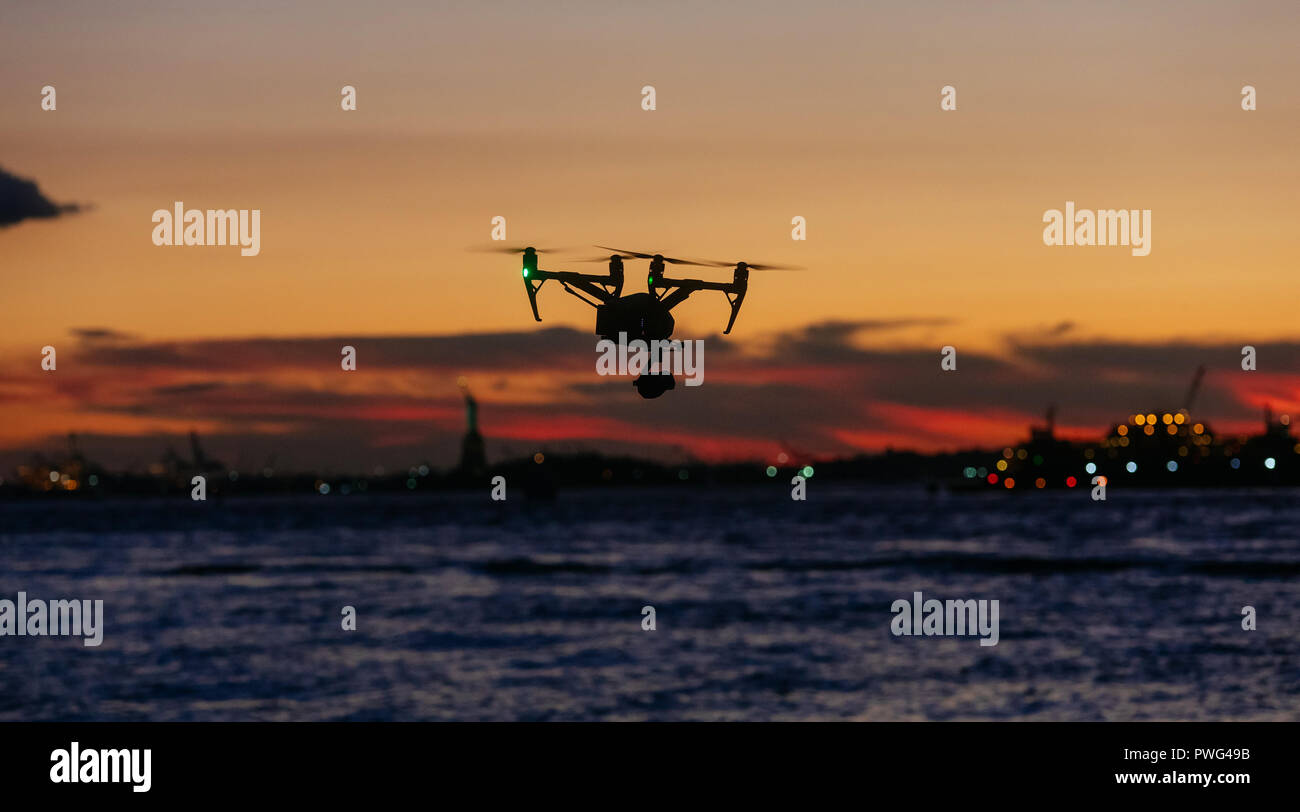 Flying drone against colored by sunset, of New York at dark sky Stock ...