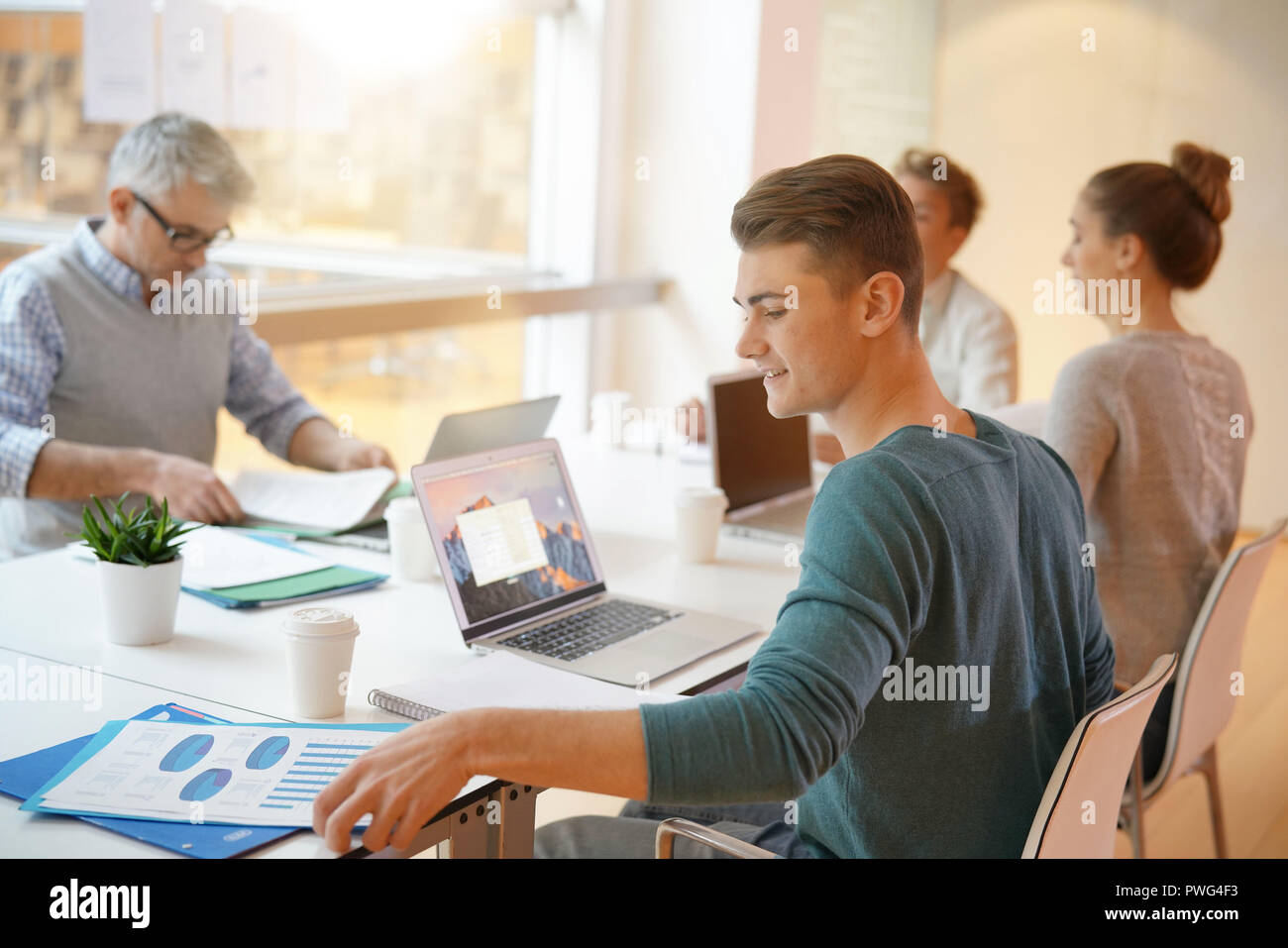 Teacher meeting around table with students Stock Photo - Alamy