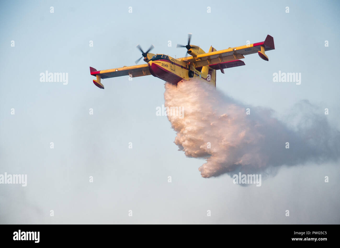 firefighting aircraft, canadair in action, throwing water into the fire ...