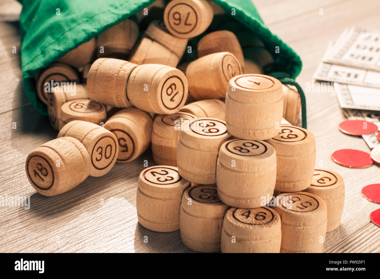 Board game lotto. Wooden lotto barrels with green bag, red chips and ...