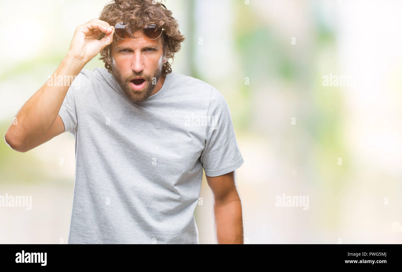 Handsome hispanic model man wearing sunglasses over isolated background ...